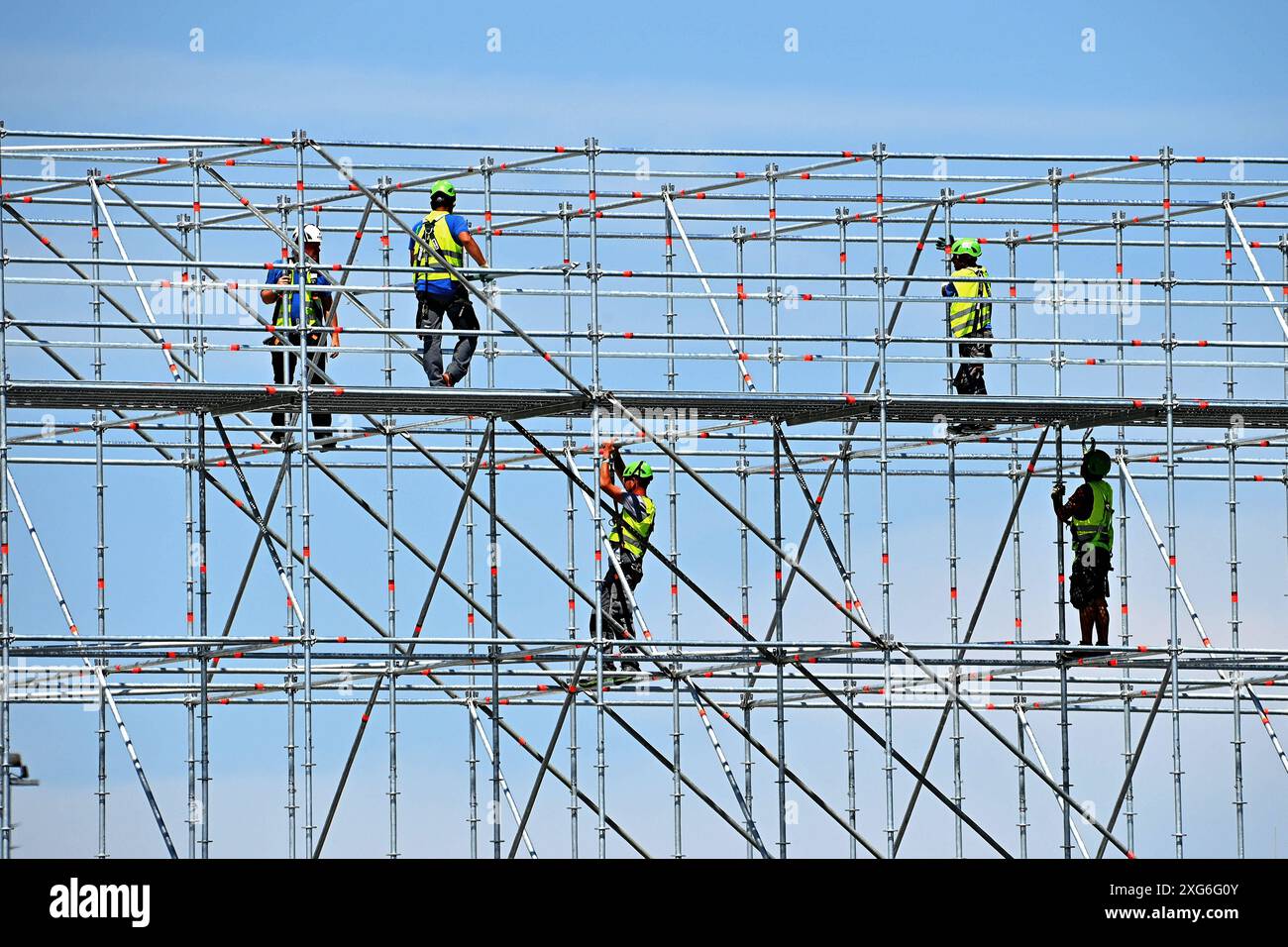 Geruestbauer in luftiger Hoehe bei der Arbeit. Aufbau einer riesigen Open Air Arena fuer die ...