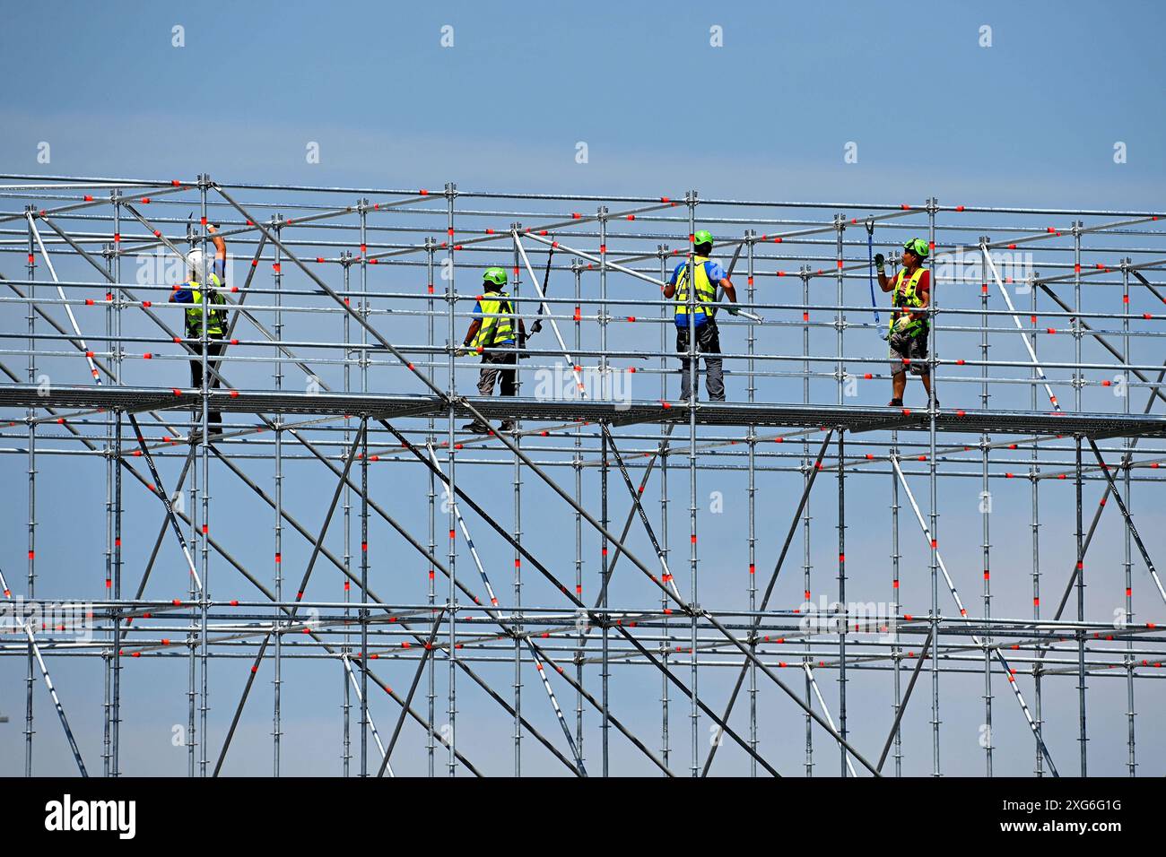 Geruestbauer in luftiger Hoehe bei der Arbeit. Aufbau einer riesigen Open Air Arena fuer die ...