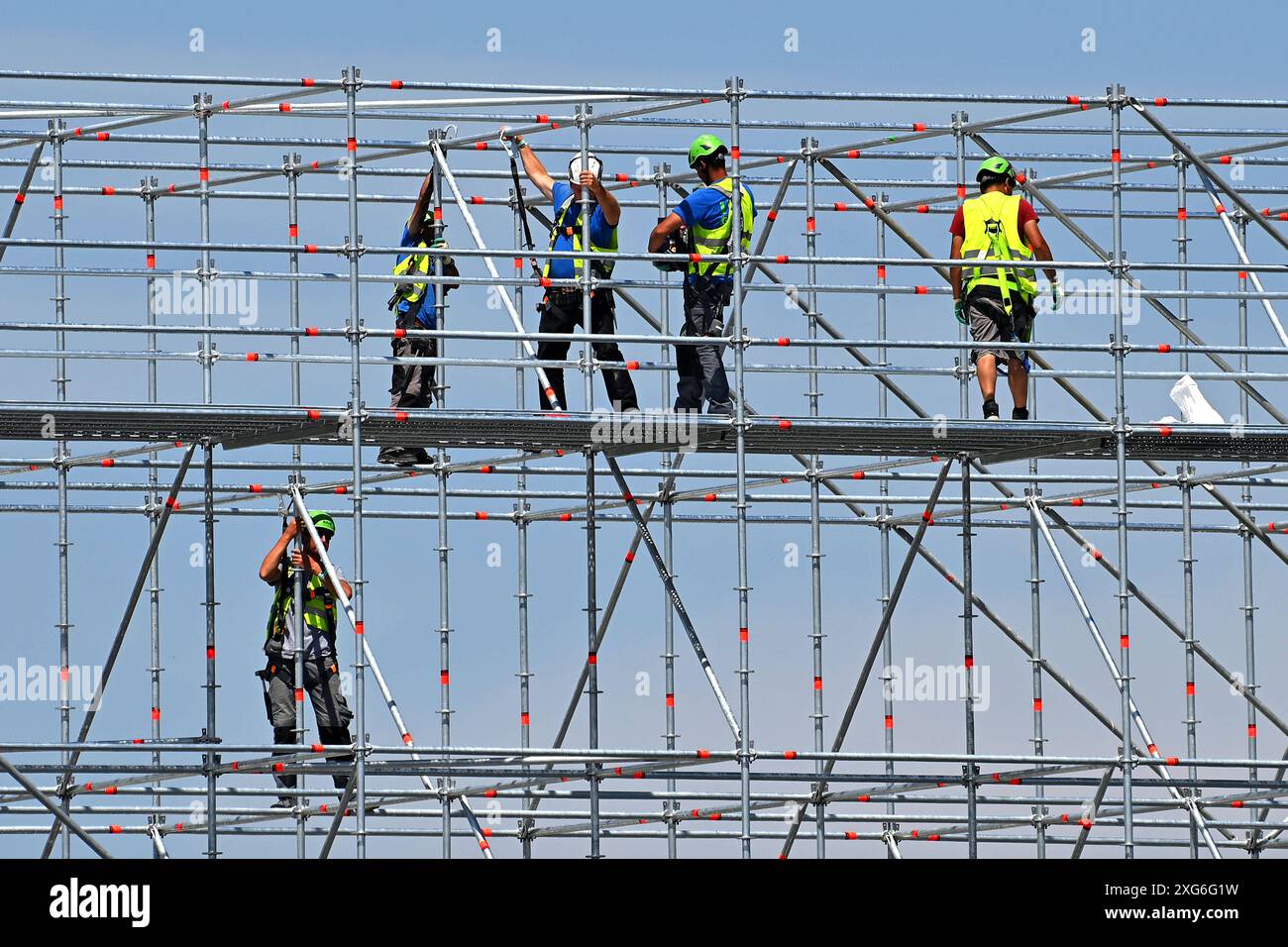 Geruestbauer in luftiger Hoehe bei der Arbeit. Aufbau einer riesigen Open Air Arena fuer die ...