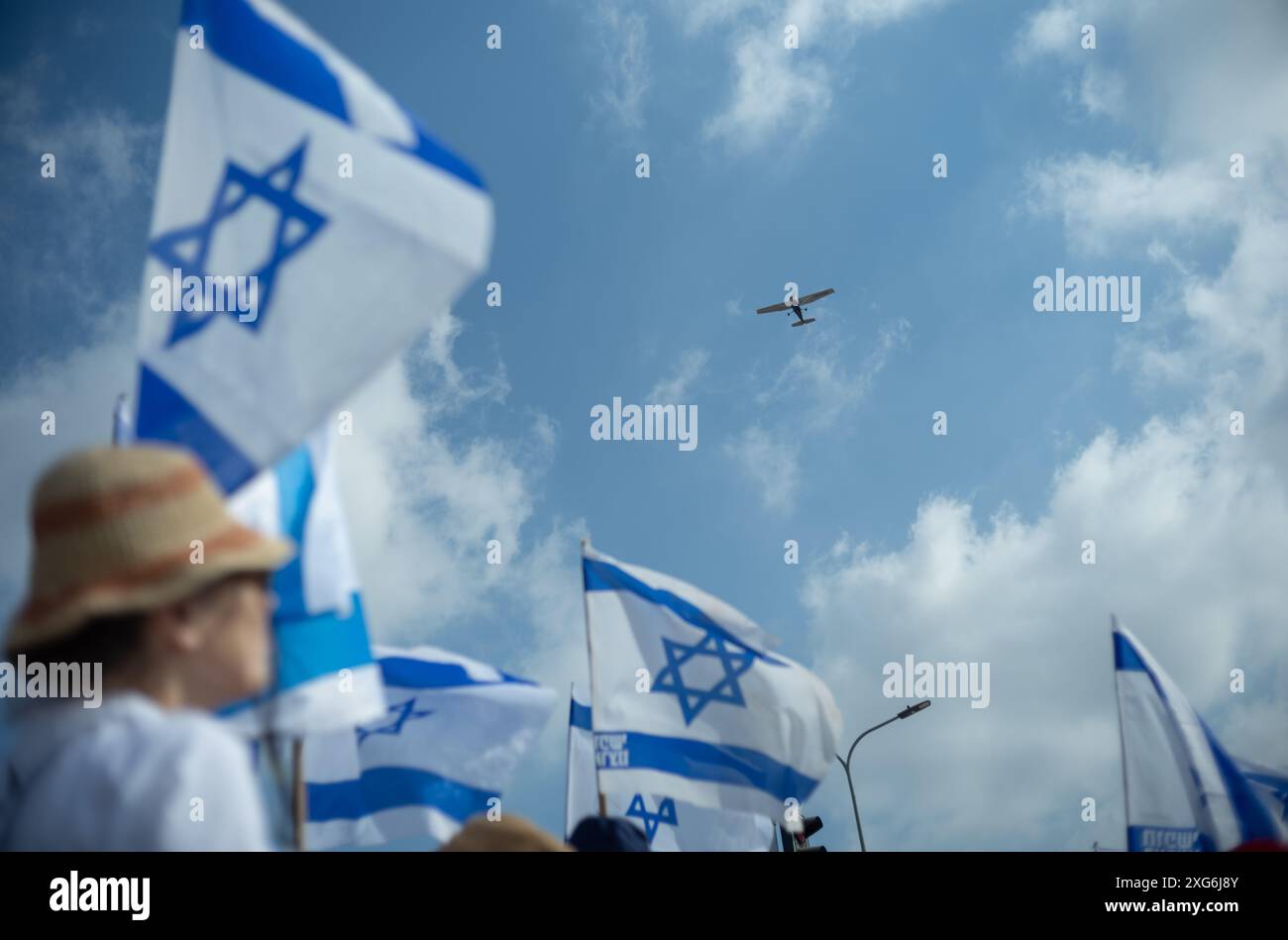 Raanana, Israel. 07th July, 2024. A plane flies over Israeli protesters ...