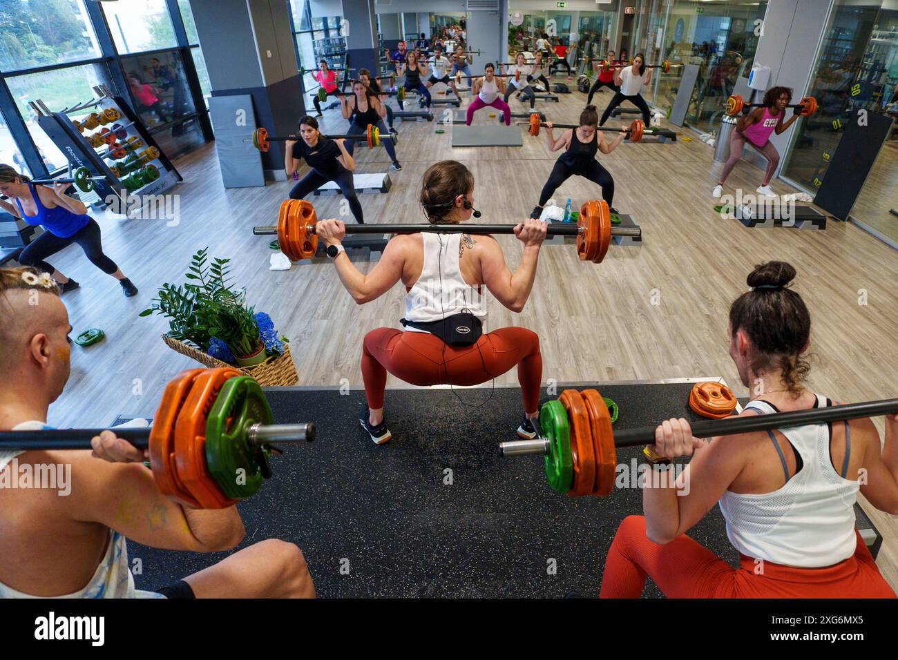 Fitness instructors doing squats during Les Mills Body Pump fitness ...