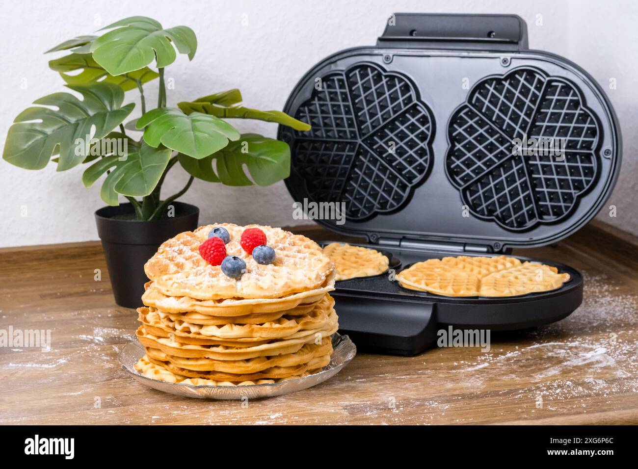 Making waffles at home. Waffle maker and stack of Belgian waffles with ...