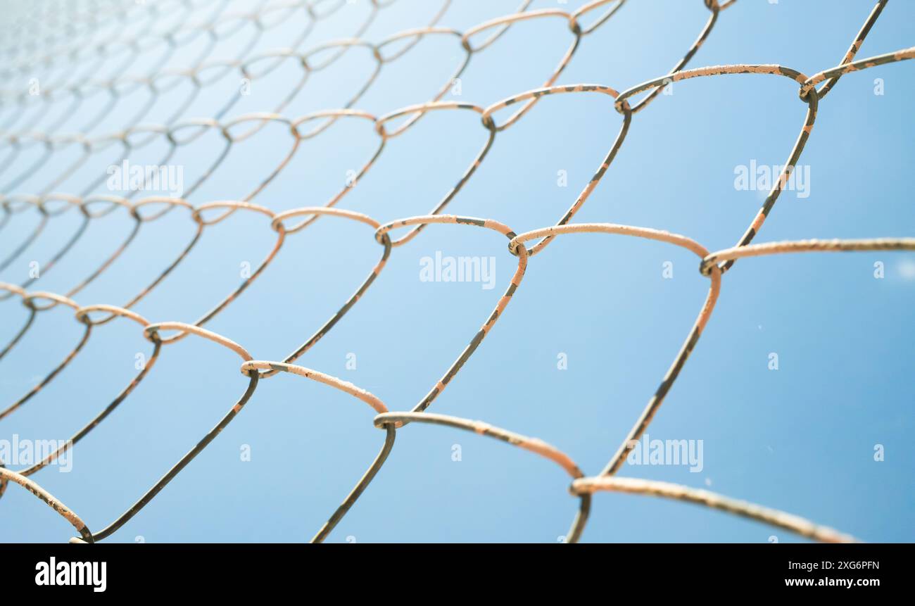 metal fence wire net on blue sky background Stock Photo - Alamy