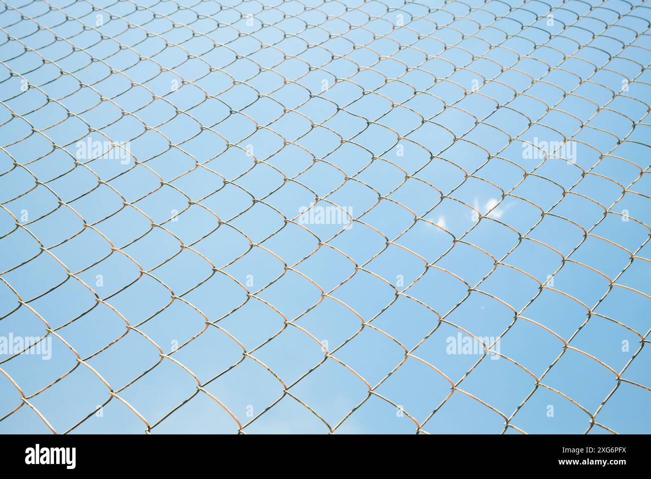 metal fence wire net on blue sky background Stock Photo - Alamy