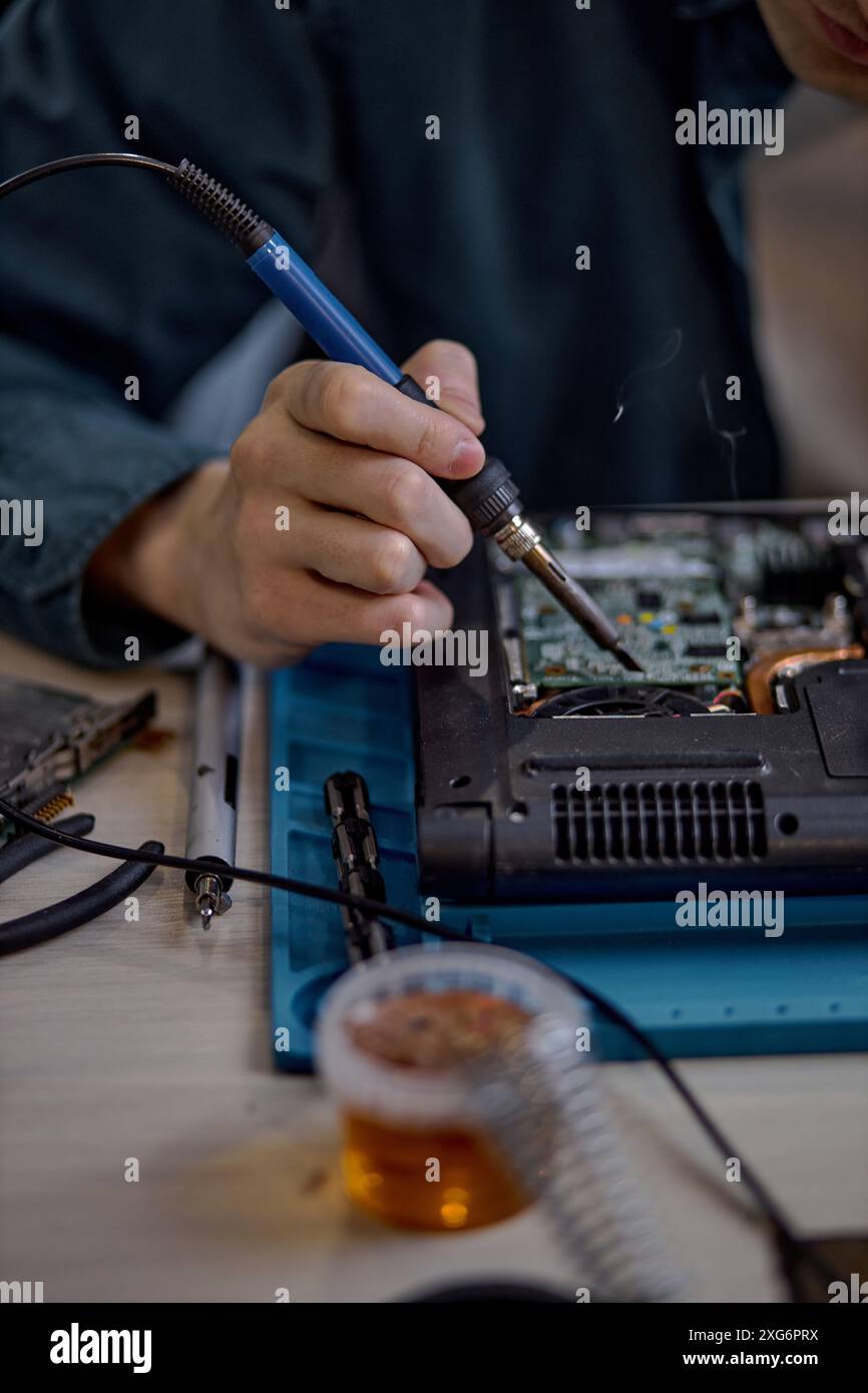 Hand technician repairing broken laptop notebook computer with tools ...