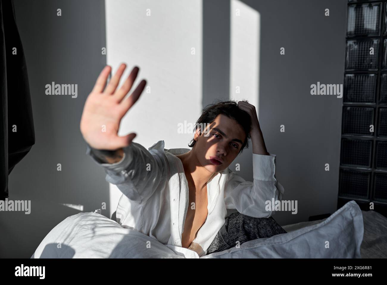 young attractive man in stylish white shirt hiding from the sun, guy ...