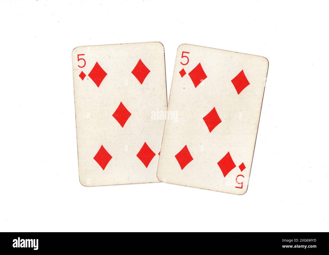 A pair of vintage five of diamonds playing cards on a white background ...