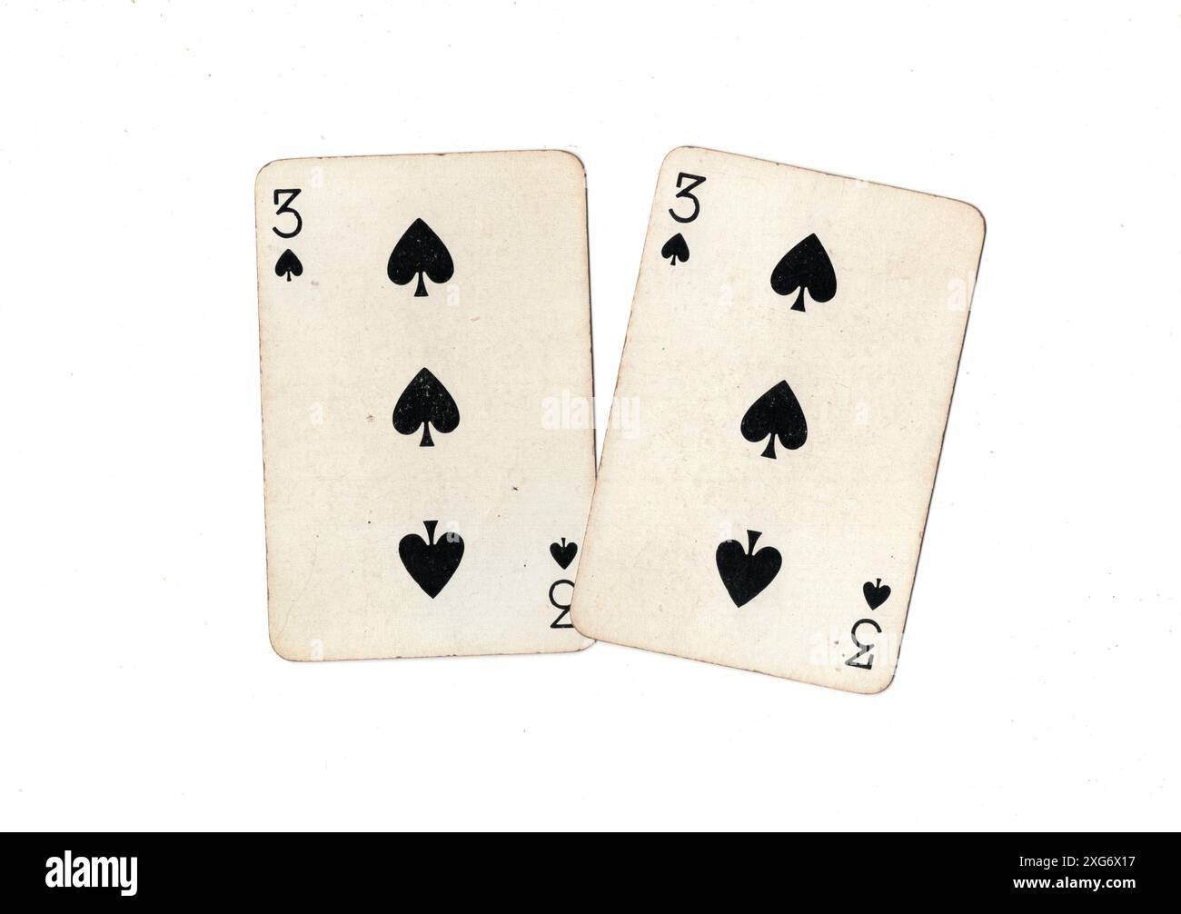 A pair of vintage three of spades playing cards on a white background ...
