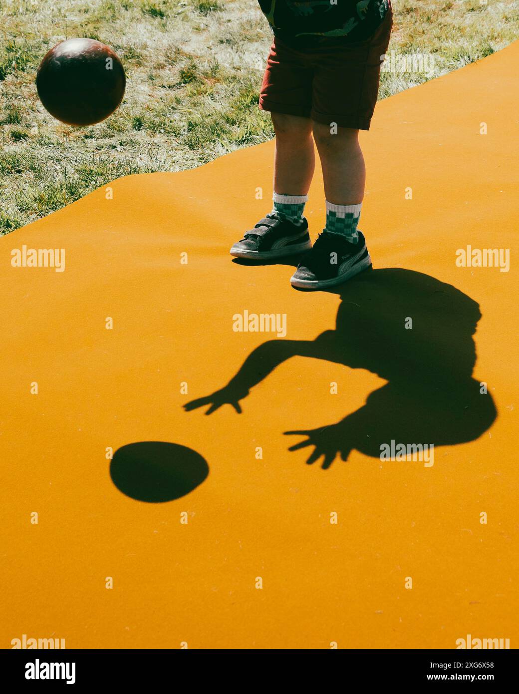 Boy child, toddler, bowling a ball while playing a game of skittles ...