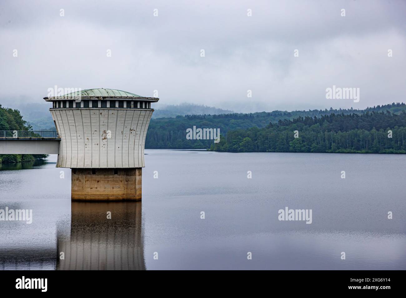Gileppe Dam with an intake or outlet tower protruding from lake waters ...