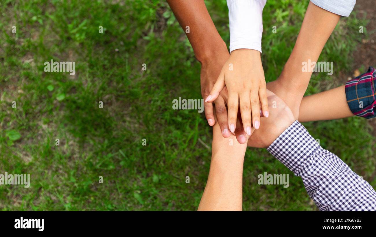Unity and teamwork. College students putting hands together Stock Photo ...