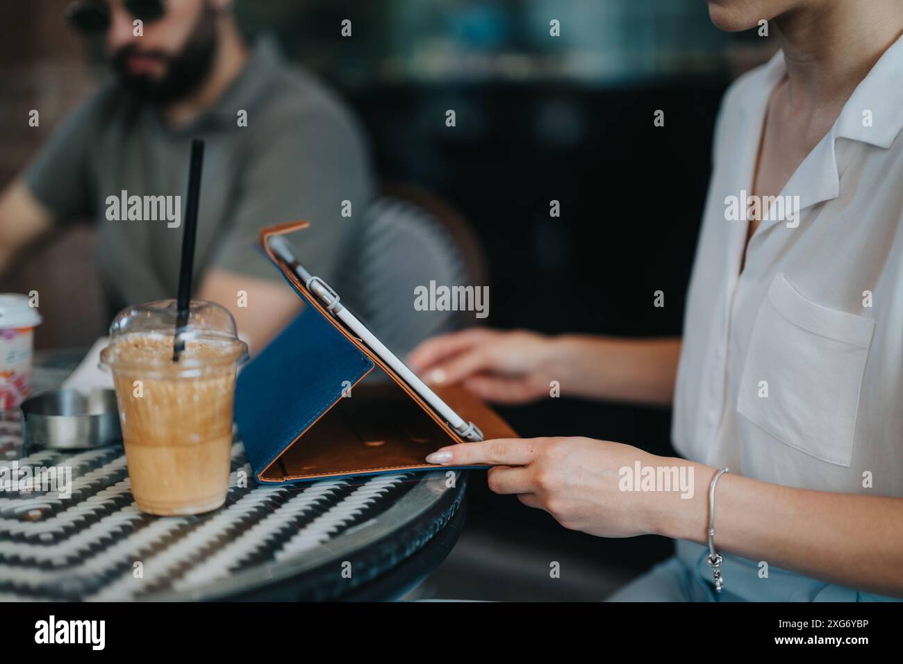 Business meeting between two partners in coffee shop with tablet and ...