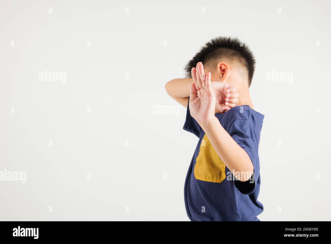Asian portrait cute young kid boy smiling doing show stop sign gesture ...