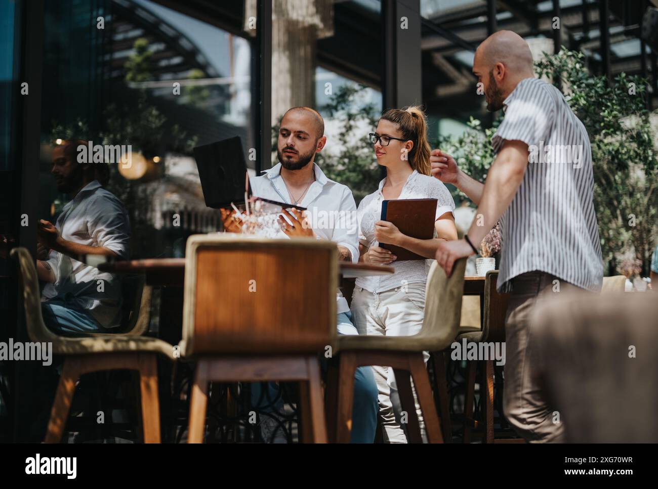 Business workers collaborating on a project in a coffee bar ...