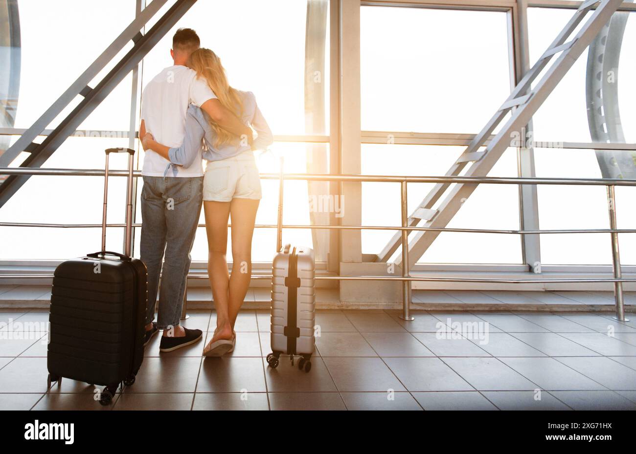 Traveling concept. Couple hugging in airport terminal Stock Photo - Alamy