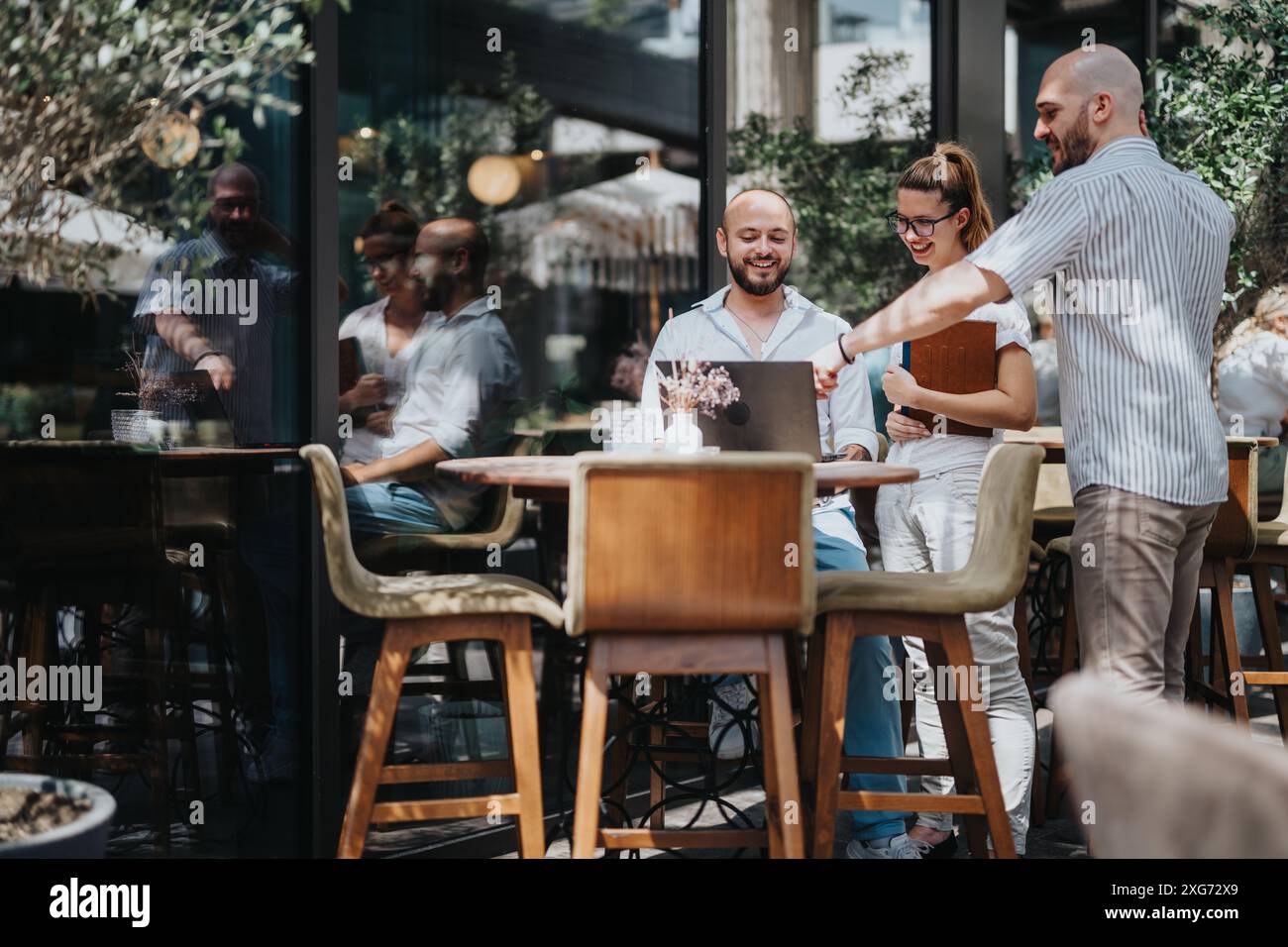 Business workers collaborating together in a coffee bar, brainstorming ...