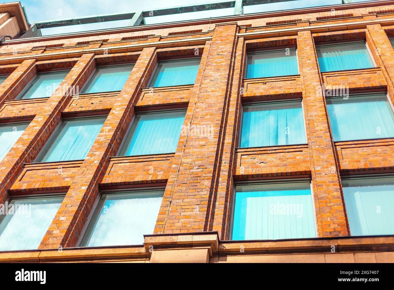 Tall building with numerous windows, reflecting the sunlight on a clear ...