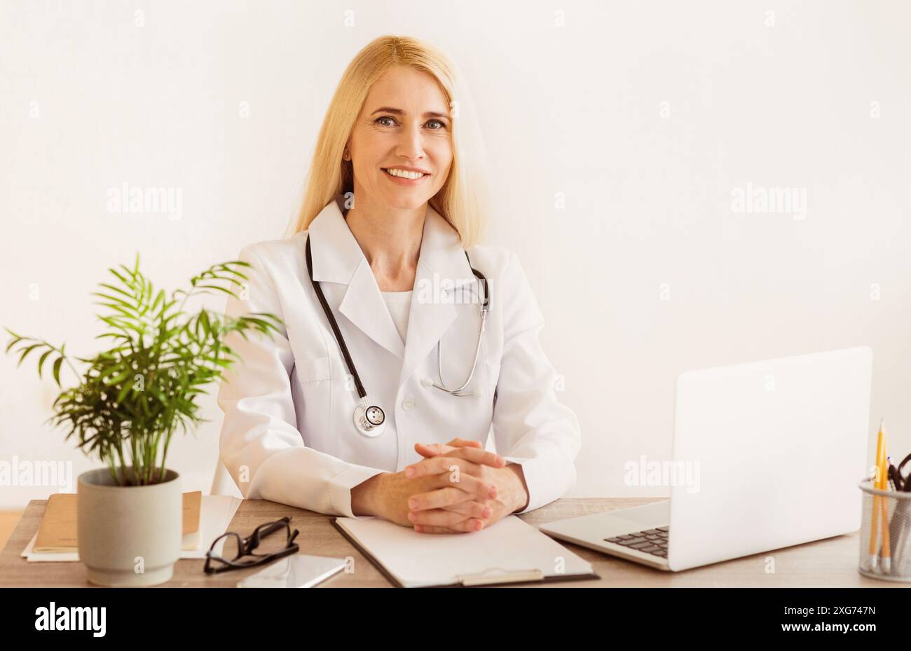 Female Doctor Sitting at Desk With Laptop Stock Photo - Alamy