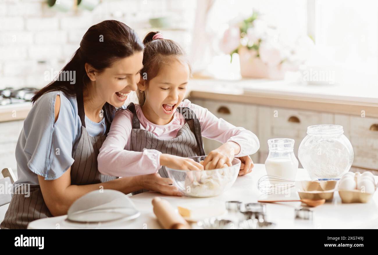 Mother daughter mixing dough together hi-res stock photography and ...