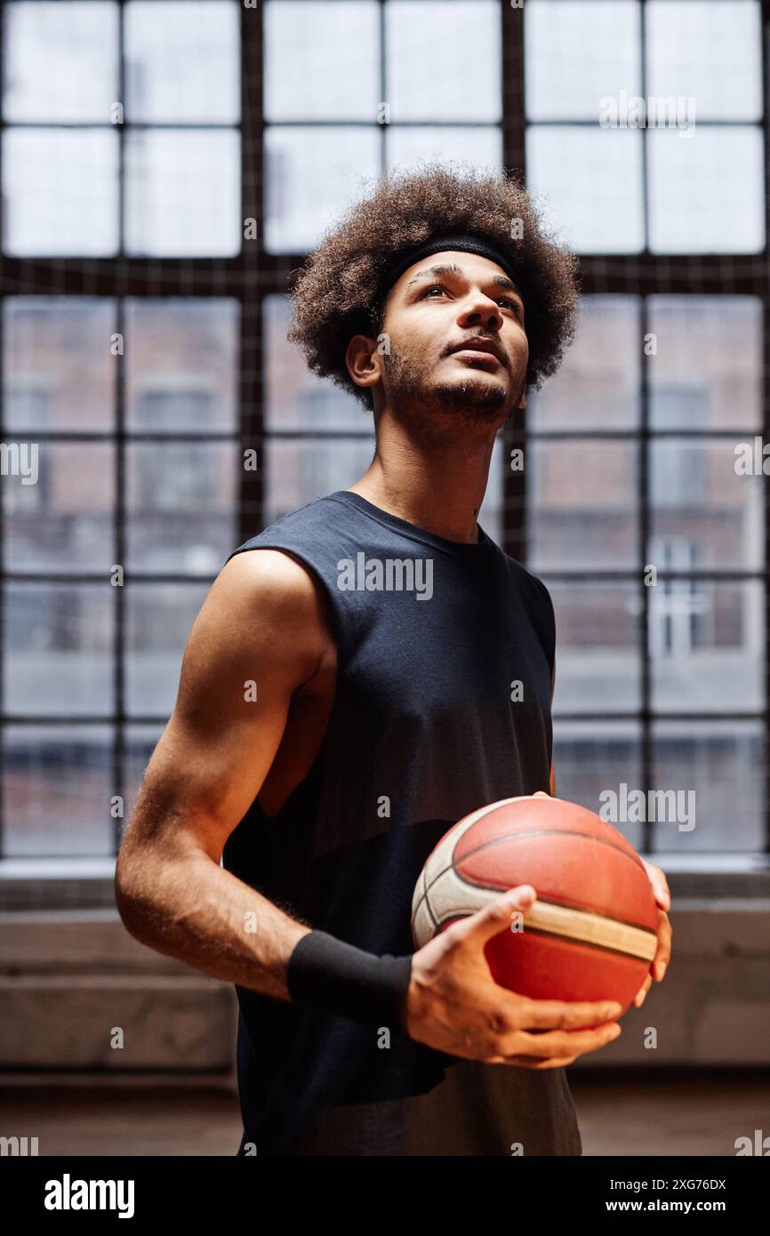 Vertical portrait of young African American man as a basketball player ...