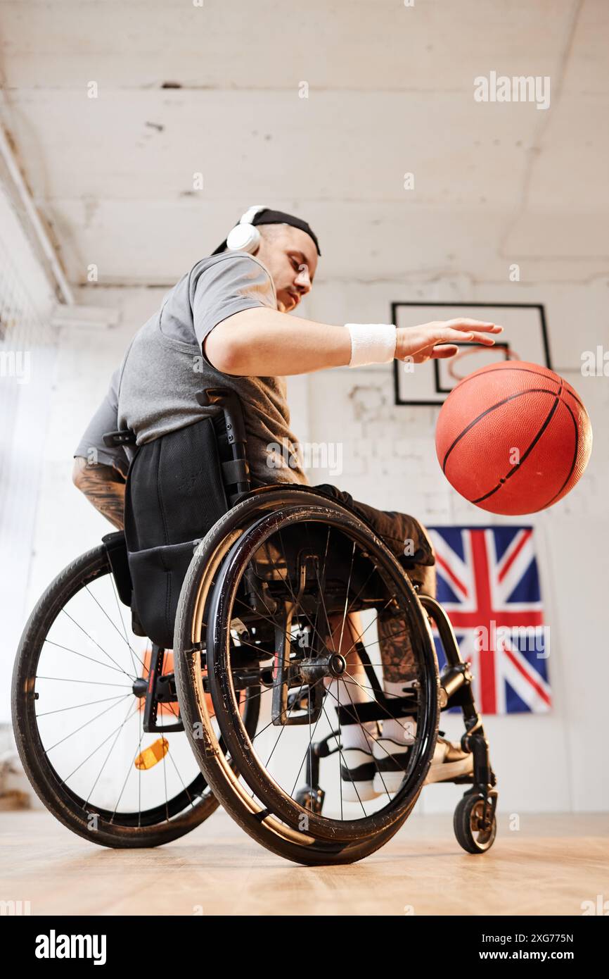 Vertical full length portrait of young man in wheelchair playing ...