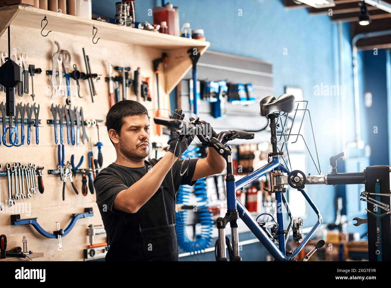 Bike repair, gears and maintenance with man in workshop for frame ...