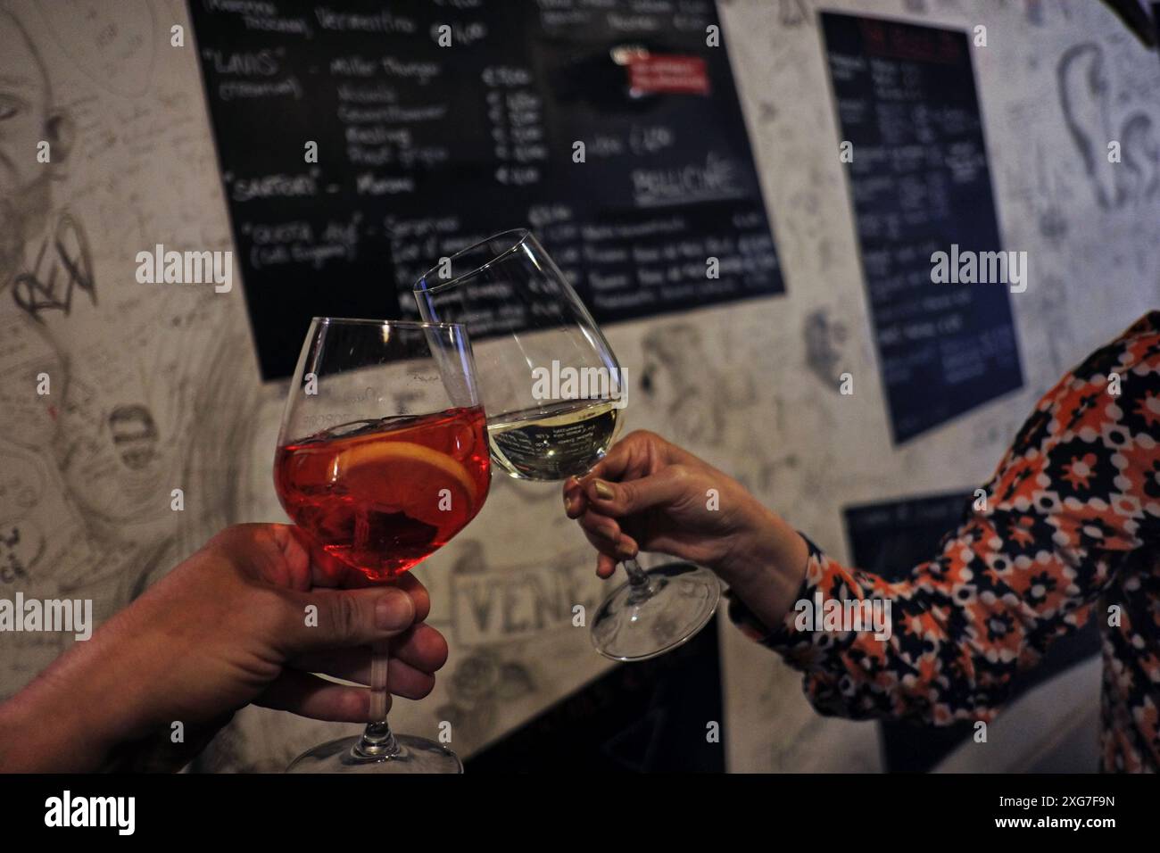 Two hands toasting with glasses of Campari Spritz & Prosecco wine at a ...
