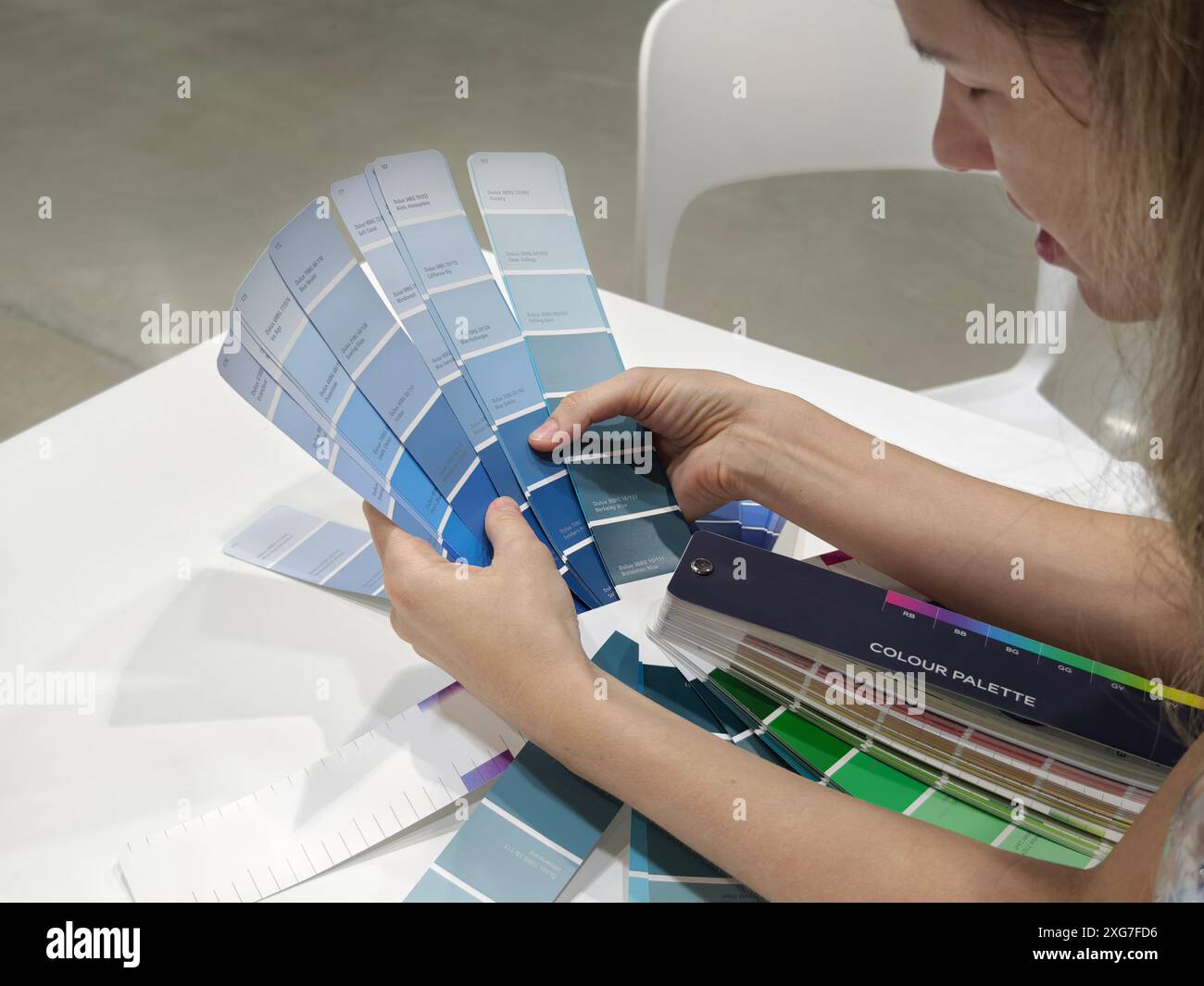 The woman is examining different paint samples at a table Stock Photo ...