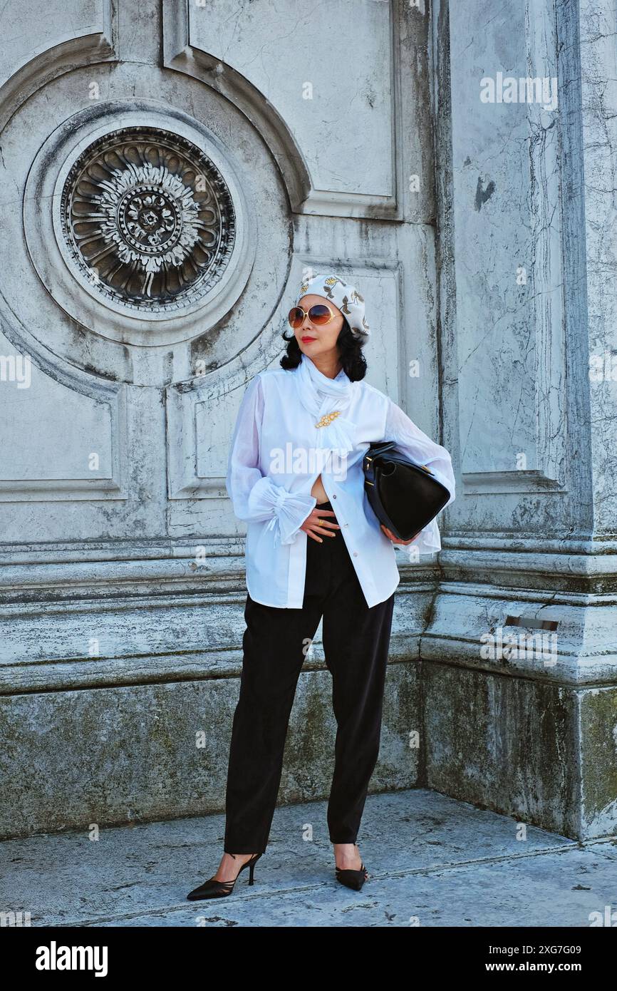 A glamorous well dressed lady wearing a fine white cotton blouse beside ...