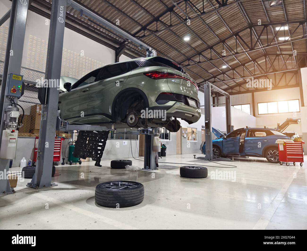 A car is raised up using a lift inside a service for maintenance Stock ...