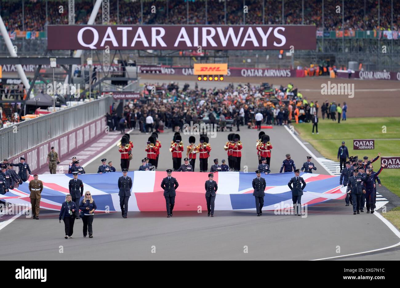 The Union flag is carried off the track by members of the armed forces ...