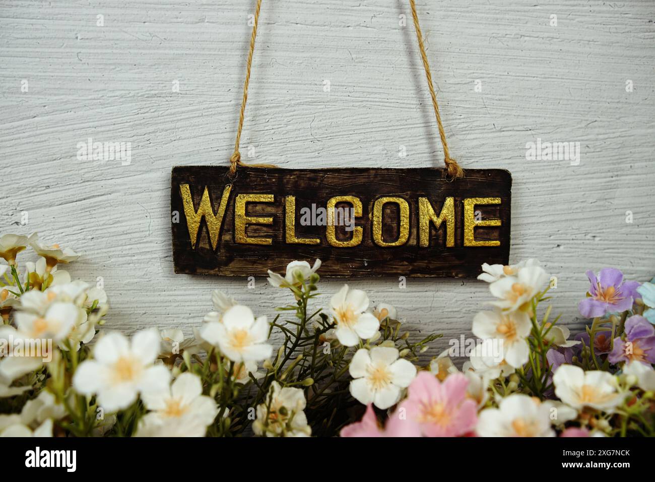 Welcome sign Hanging on grunge cement wall background Stock Photo - Alamy