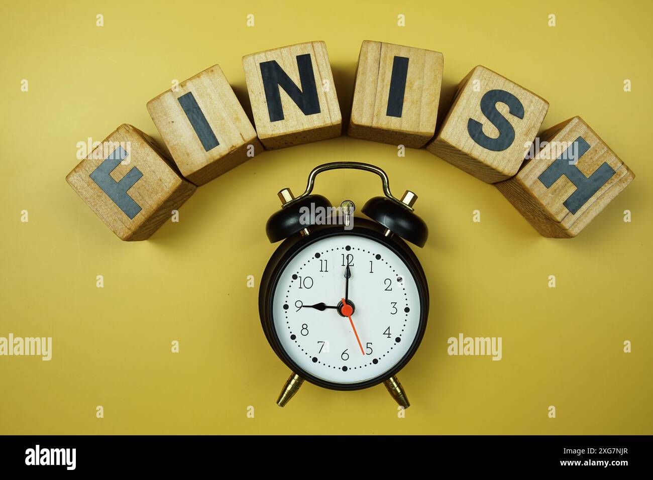 Finish alphabet letters and alarm clock top view on yellow background ...