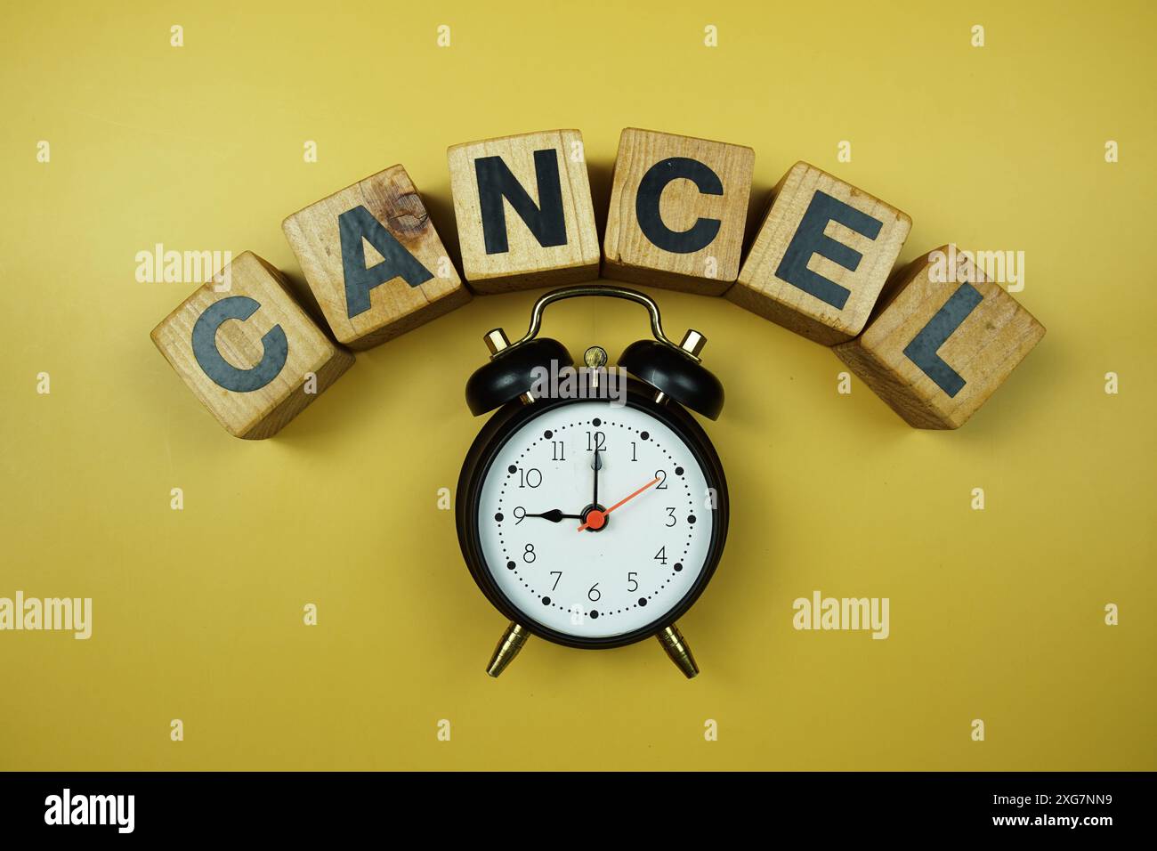 Cancel word and alarm clock top view on yellow background Stock Photo ...