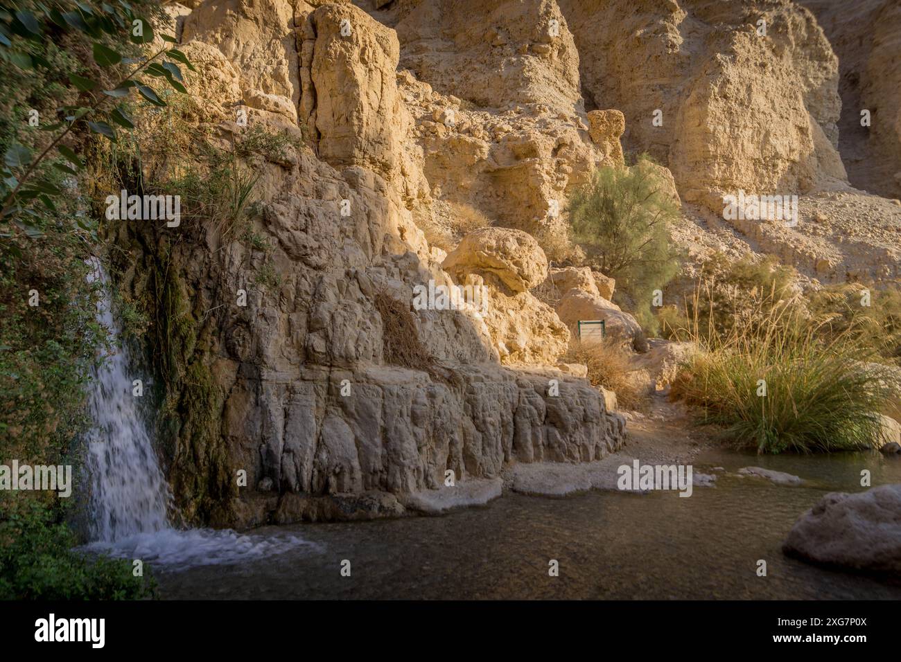 The small waterfall, little pond, and dry rocks deep in the Middle East ...