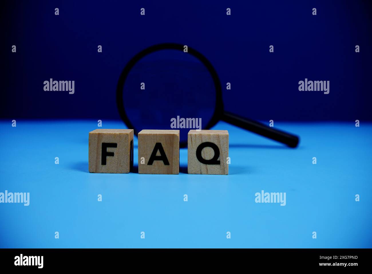 FAQ with wooden blocks alphabet letters and Magnifying glass on blue ...