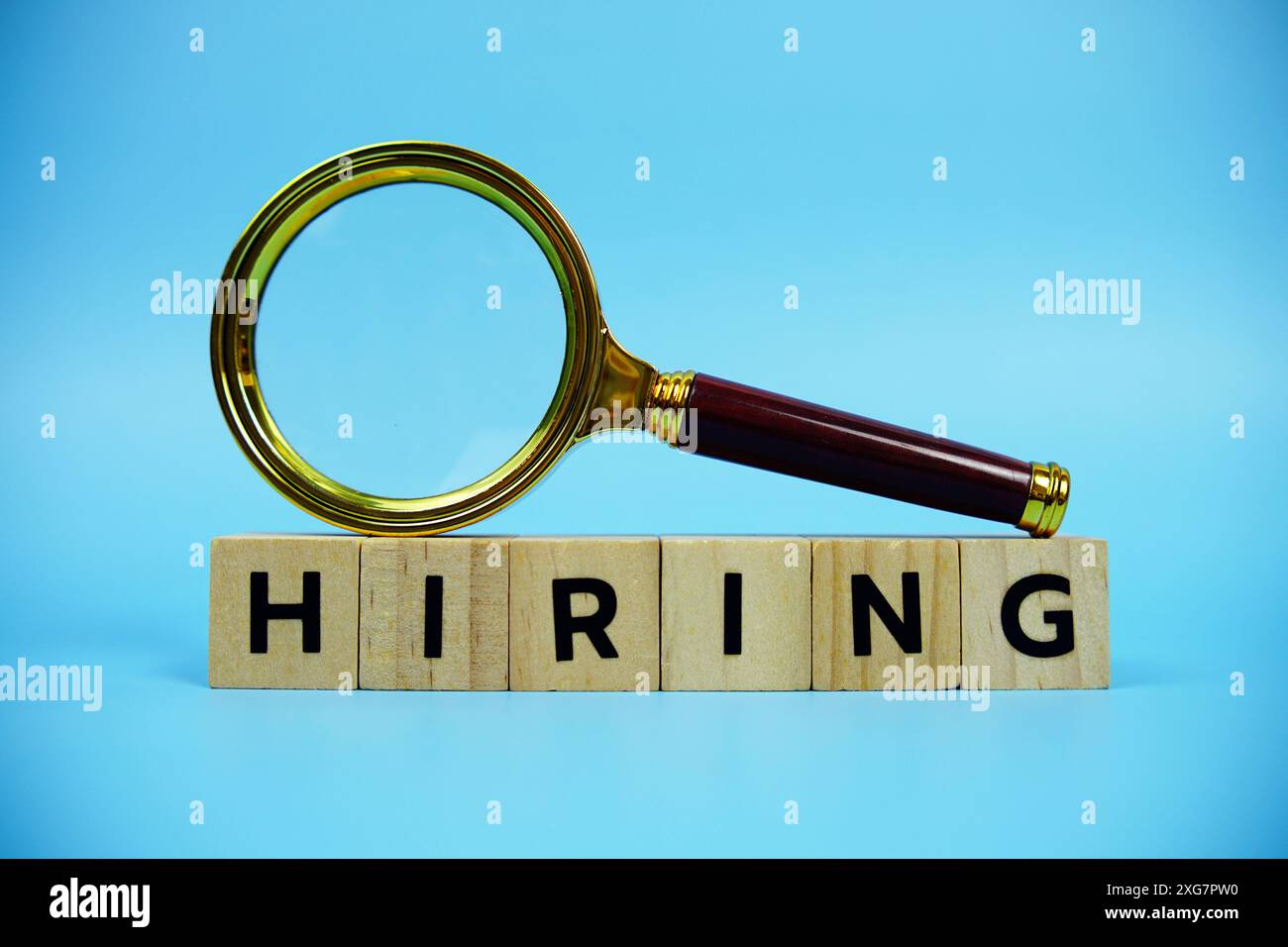 Hiring with wooden blocks alphabet letters and Magnifying glass on blue ...