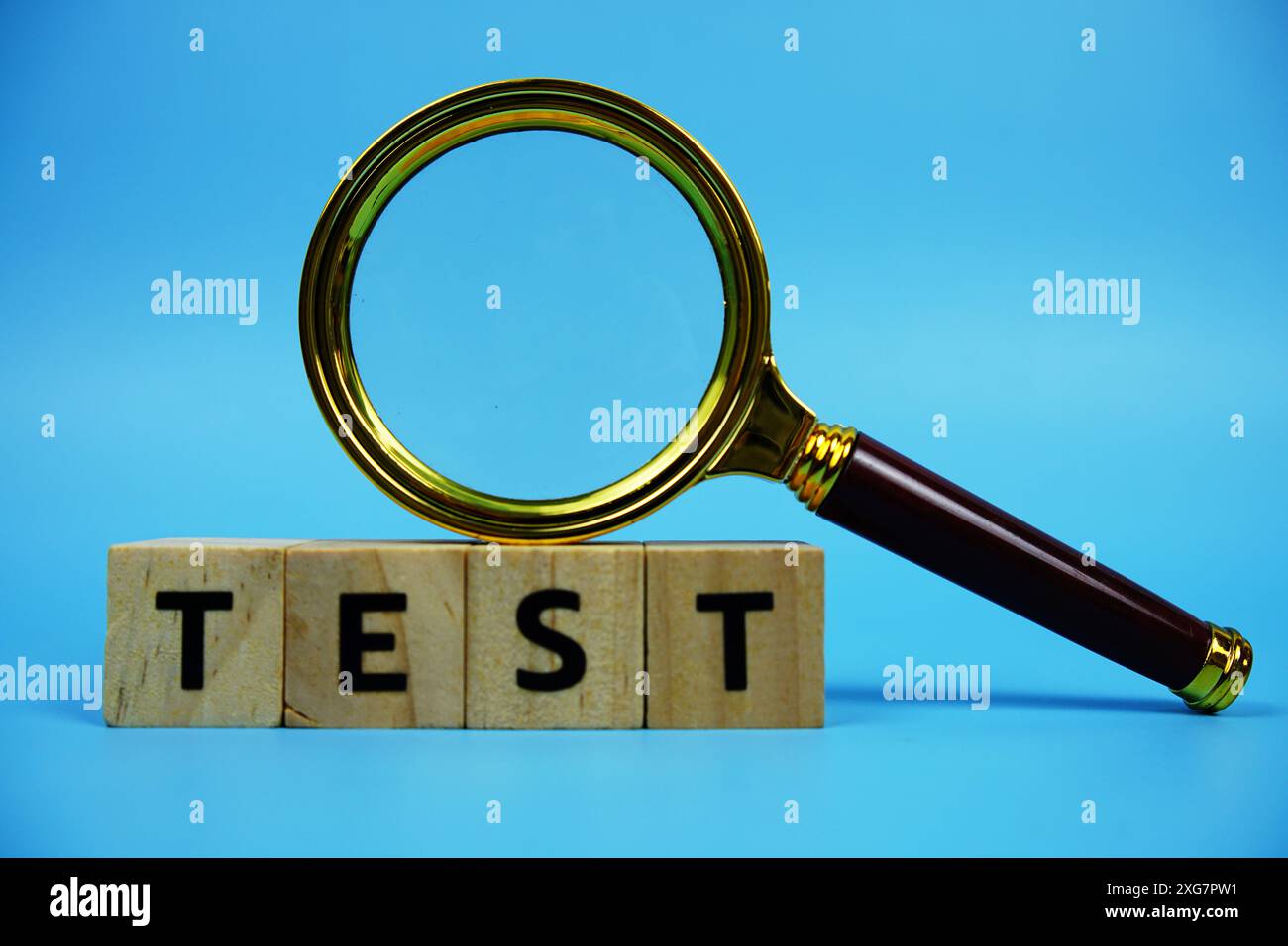 Test with wooden blocks alphabet letters and Magnifying glass on blue ...