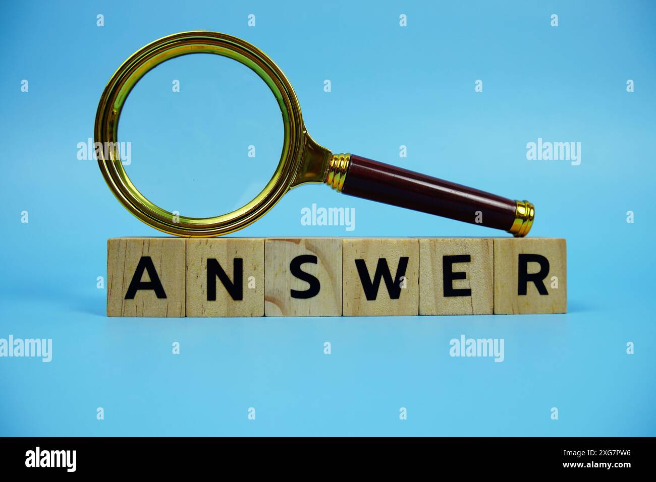 Answer with wooden blocks alphabet letters and Magnifying glass on blue ...
