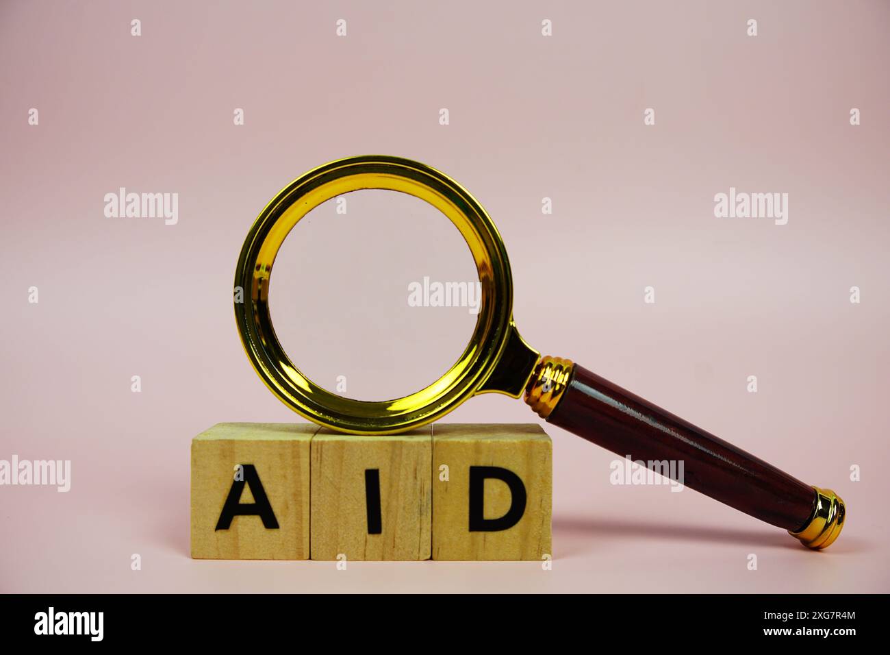 AID with wooden blocks alphabet letters and Magnifying glass on pink ...