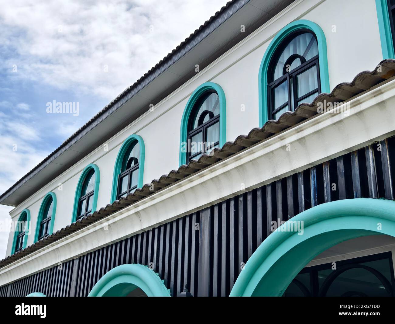 White building with arched windows, blue trim, stands tall under clear ...