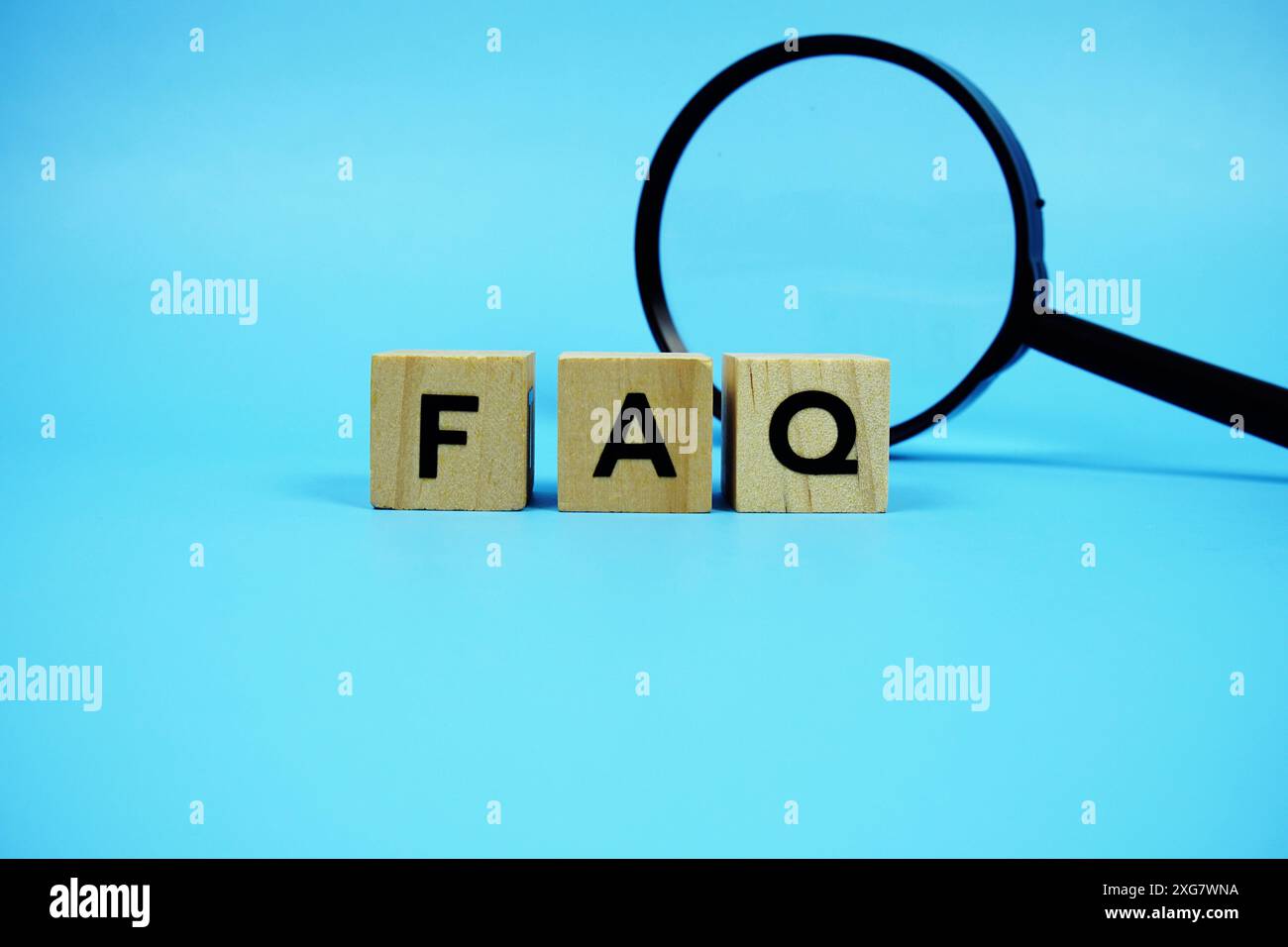FAQ with wooden blocks alphabet letters and Magnifying glass on blue ...