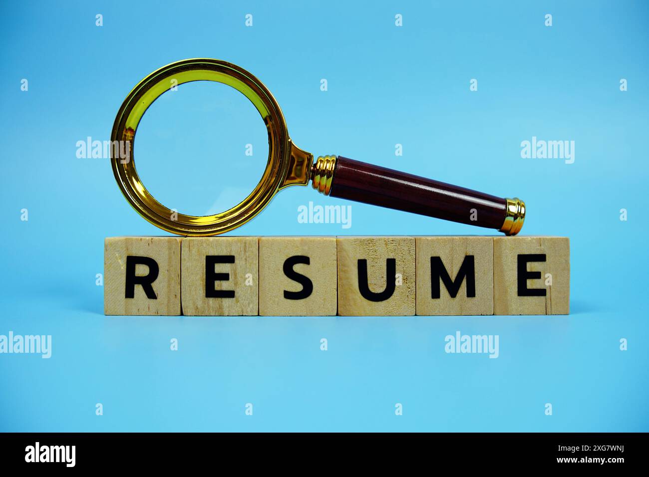 Resume with wooden blocks alphabet letters and Magnifying glass on blue ...