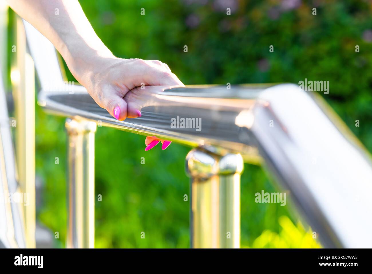 woman's hand holding onto the metal staircase railing. hand holding ...