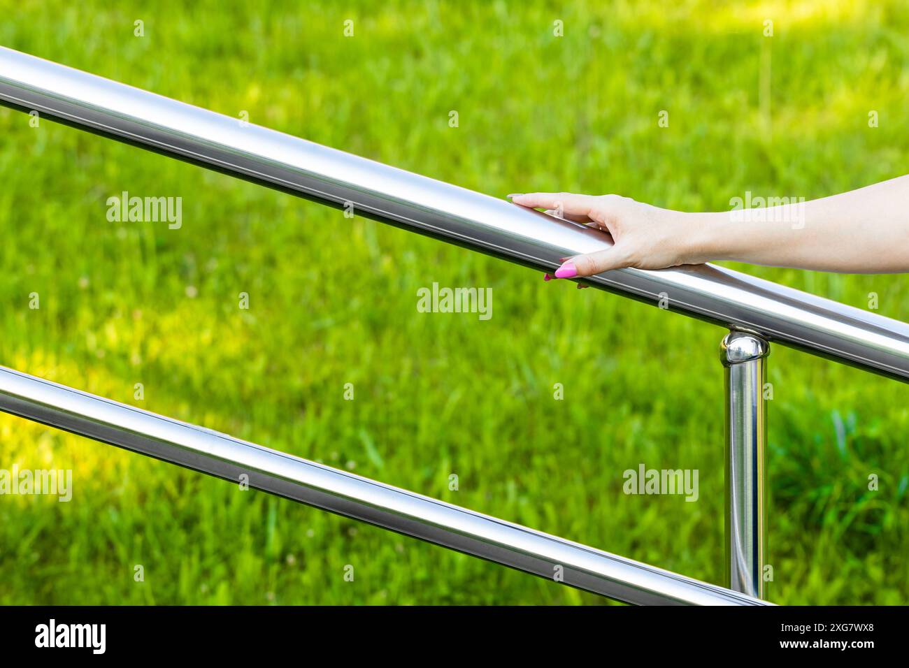 woman's hand holding onto the metal staircase railing. metal stair ...
