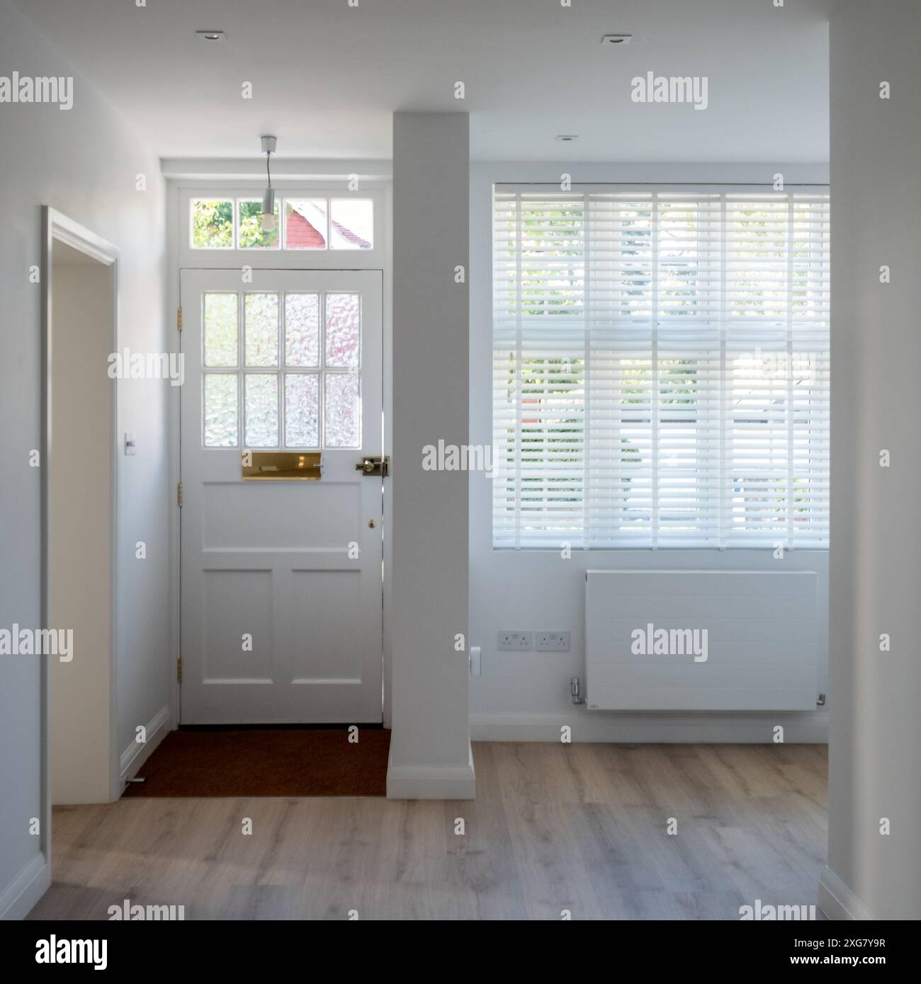 Minimalist, white painted front door and entrance hallway of an ...