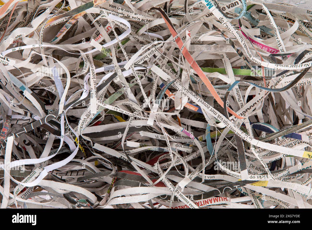 Shredded newspaper pieces are creating an abstract textured background ...