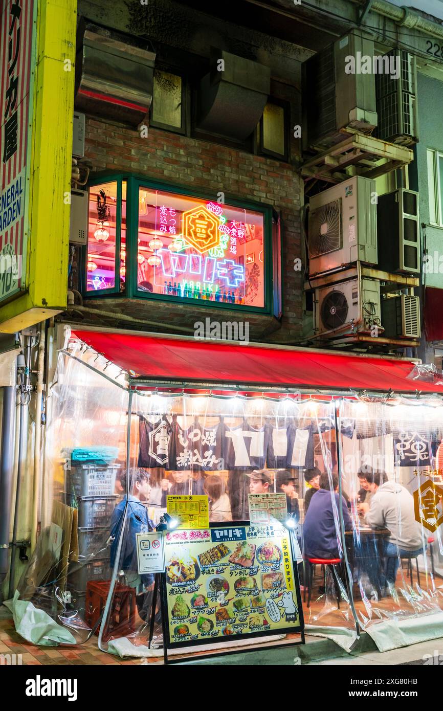 Diners, behind protecting transparent plastic curtains, eating outside ...