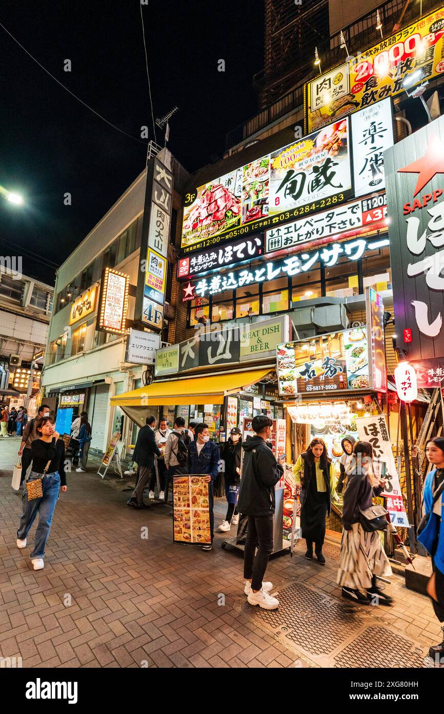 People around the entrance of two Japanese restaurants on a popular ...