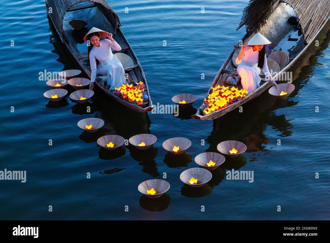Vietnamese women in wooden longboat laying lit floating lanterns on the ...